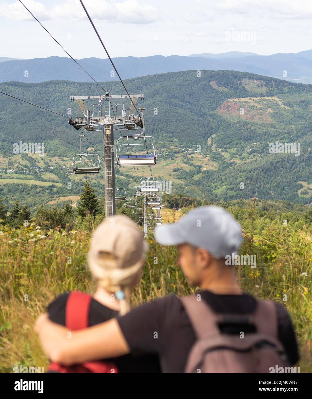 Man and a woman riding on the lift down the scenic Mountain during ...