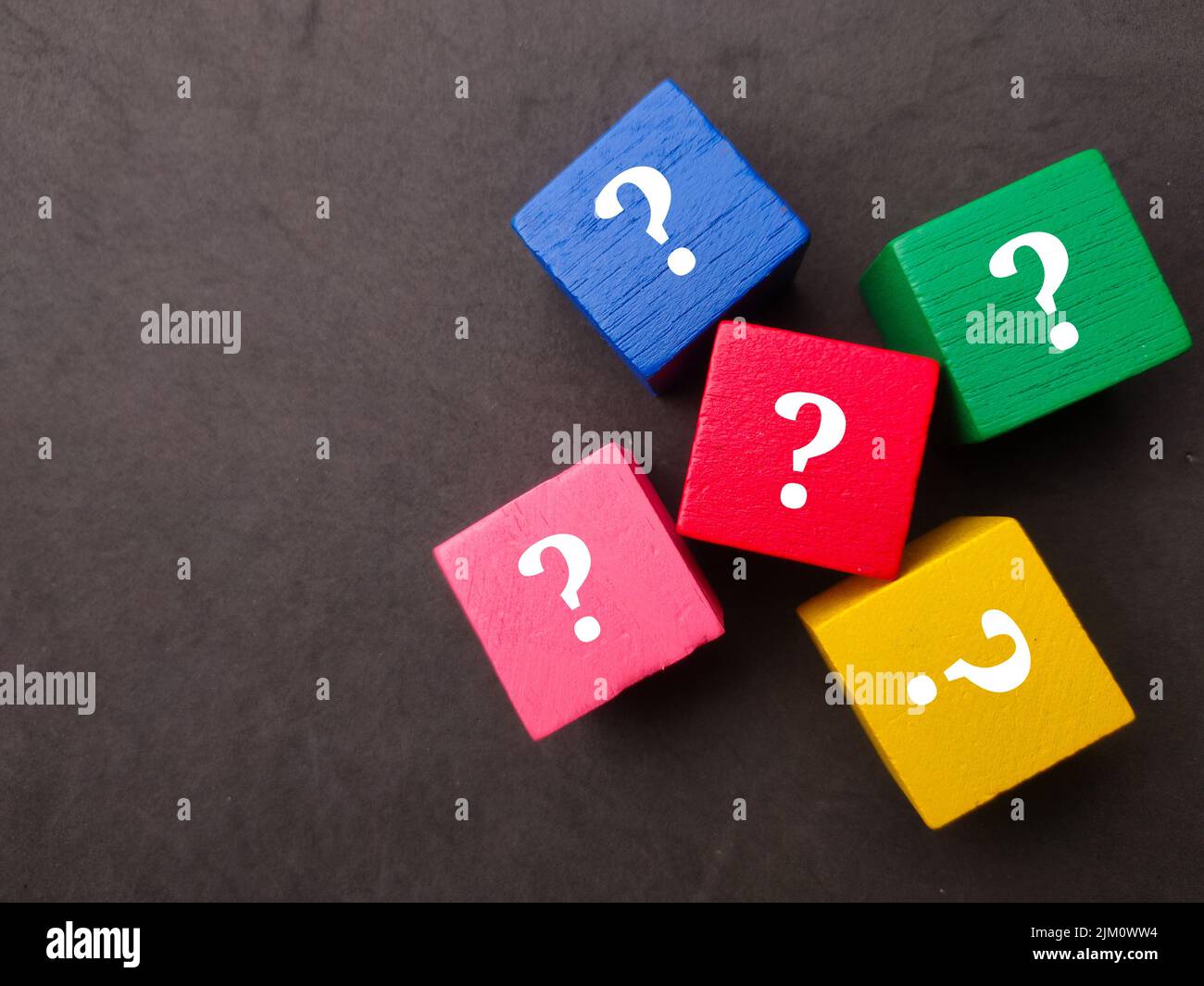 Top view colored wooden cubes with question icons. The concept of ...