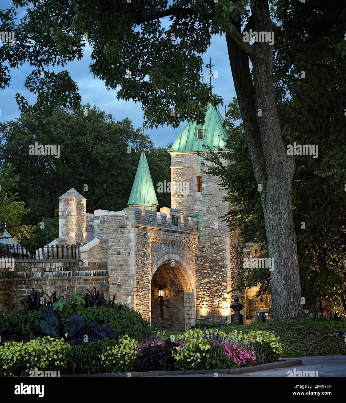 A vertical of a beautiful medieval castle gate illuminated at twilight ...