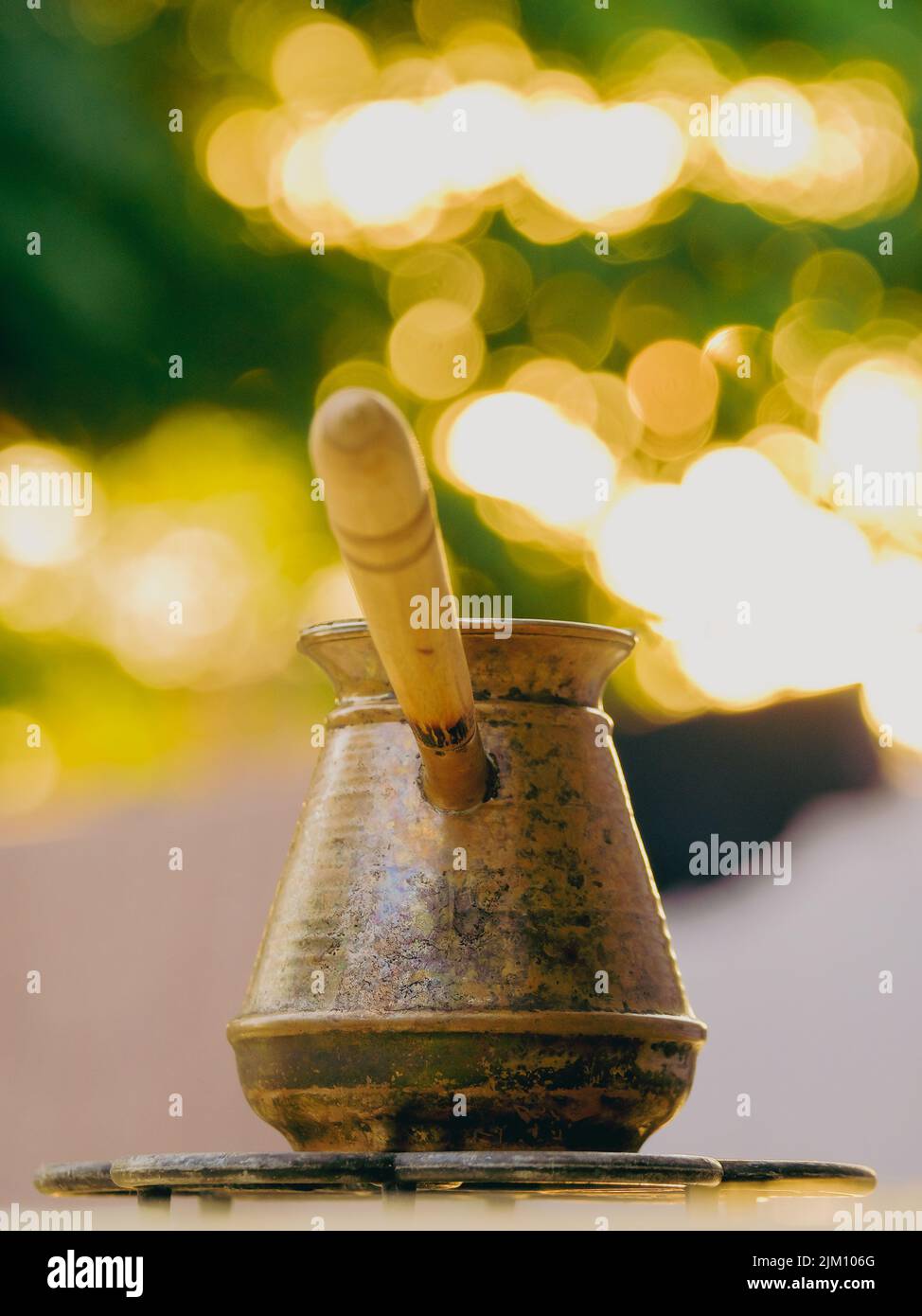 Copper smoky cezve for brewing coffee against the background of sun ...