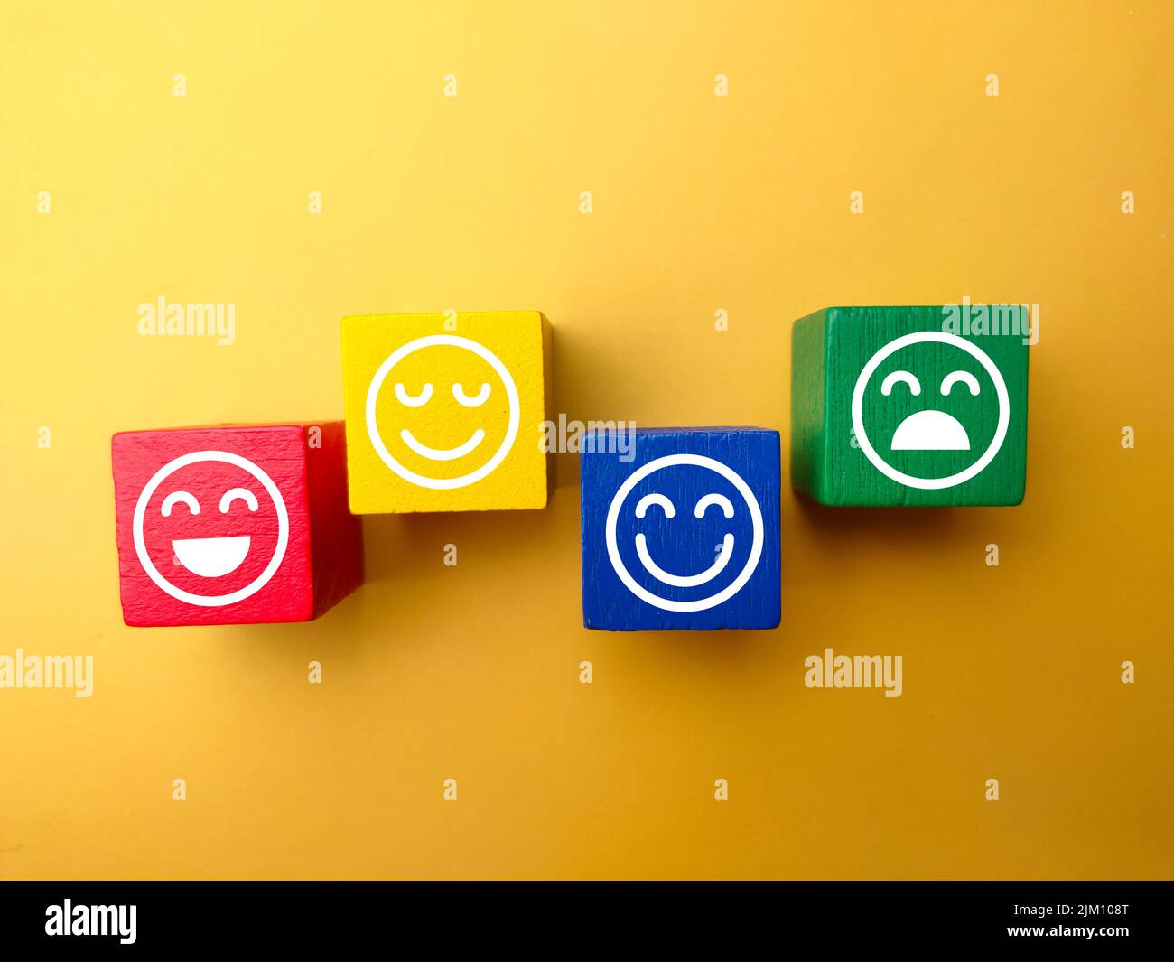 Colored wooden block with happy and unhappy expression. Positive and ...