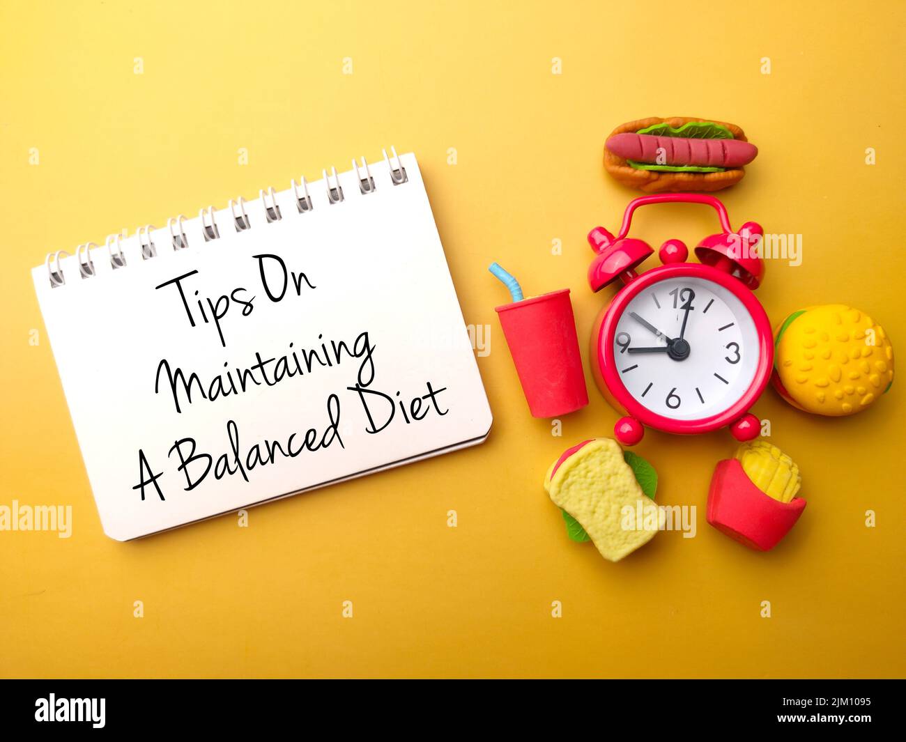 food and alarm clock with the words tips on maintaining a balanced diet ...