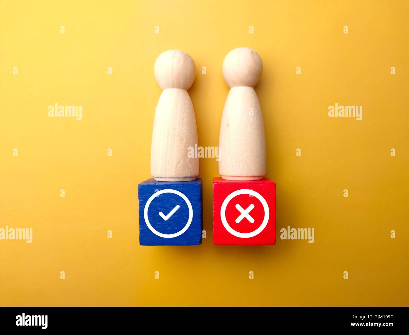 Wooden figures on a colored wooden cube with symbol correct and wrong ...