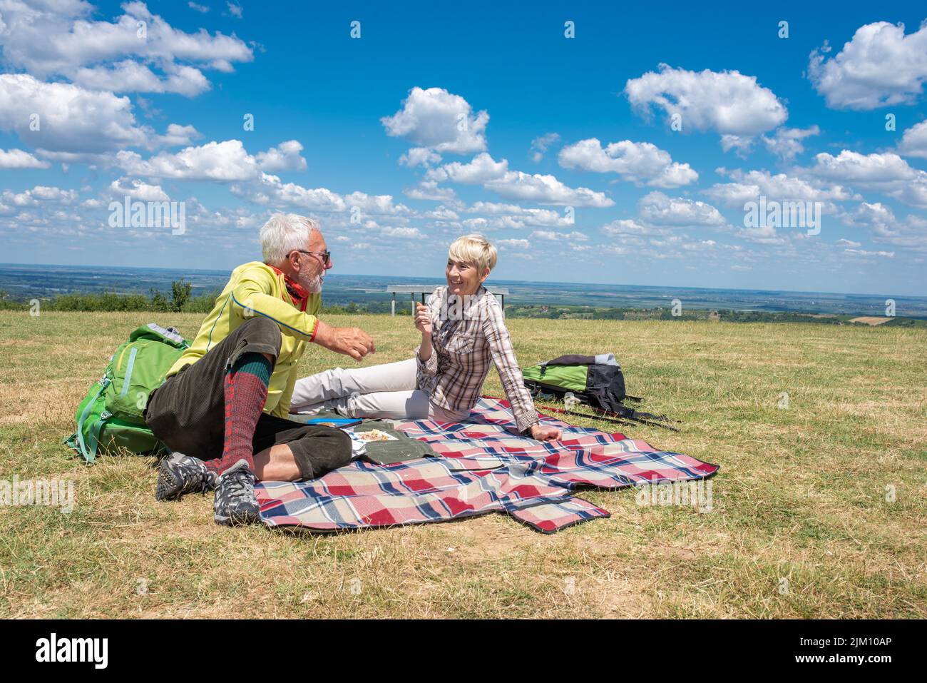 A couple having a picnic in a field at daytime Stock Photo - Alamy