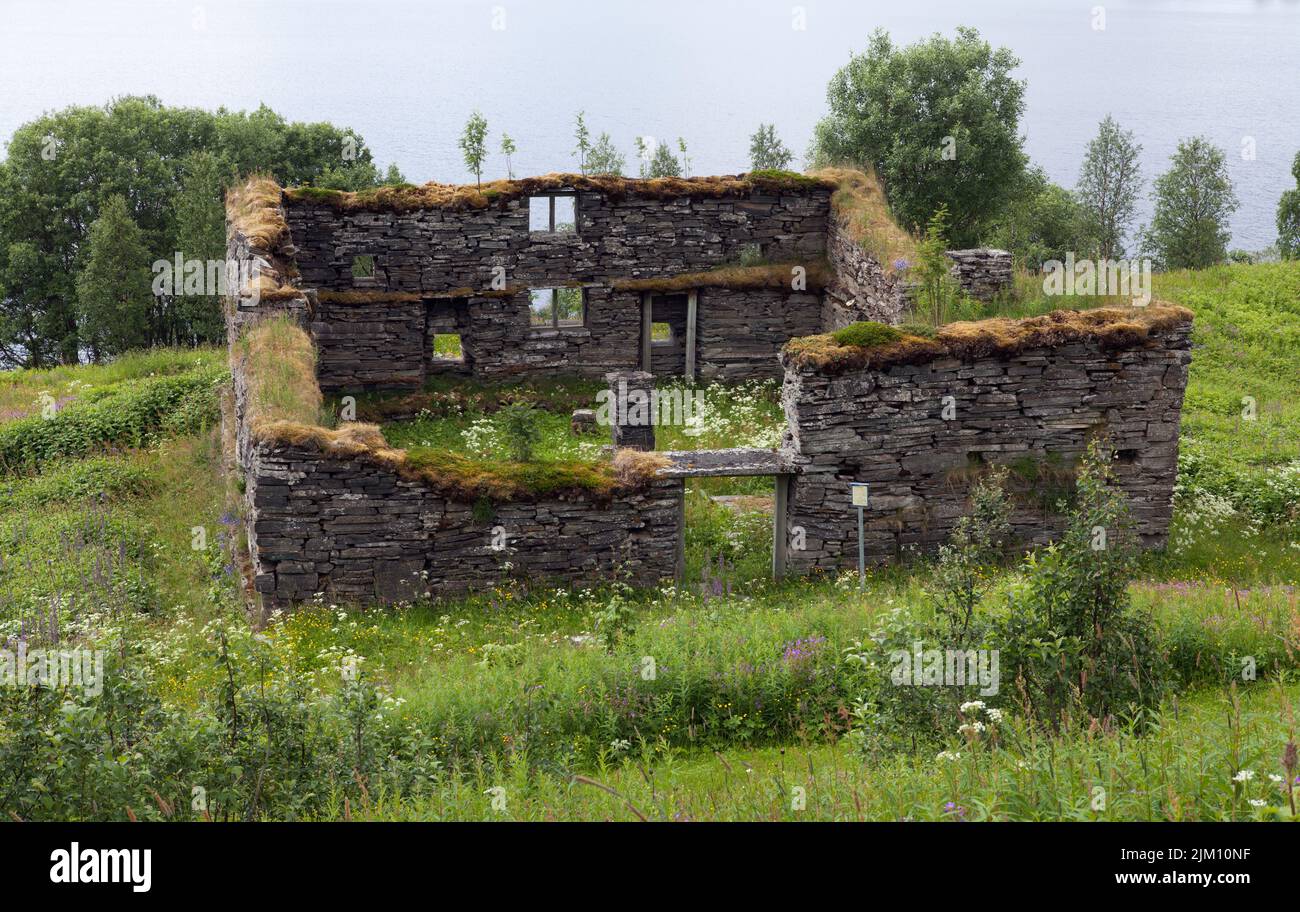Old abandoned buildings, slate stones in rural area. Meadows, plants ...