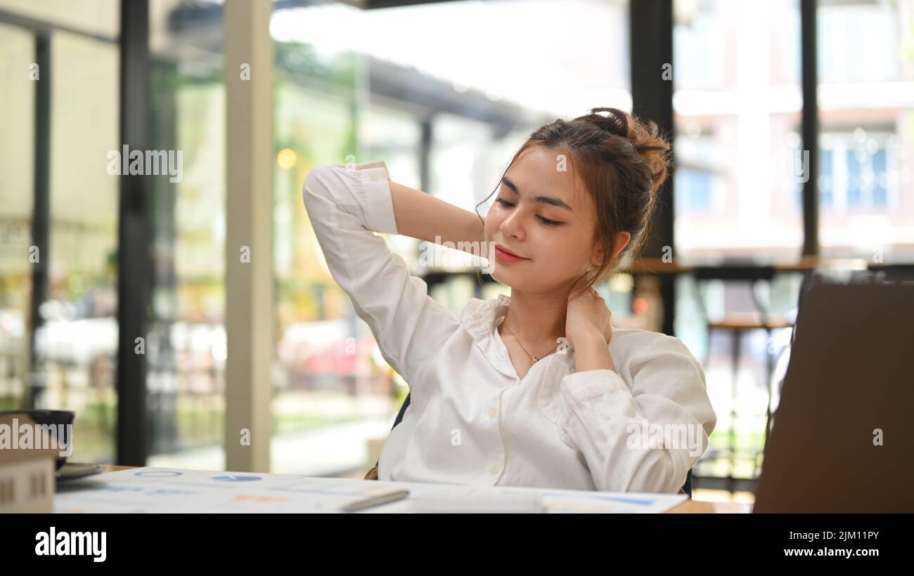 Fatigued young female employee suffering from fibromyalgia neck pain ...