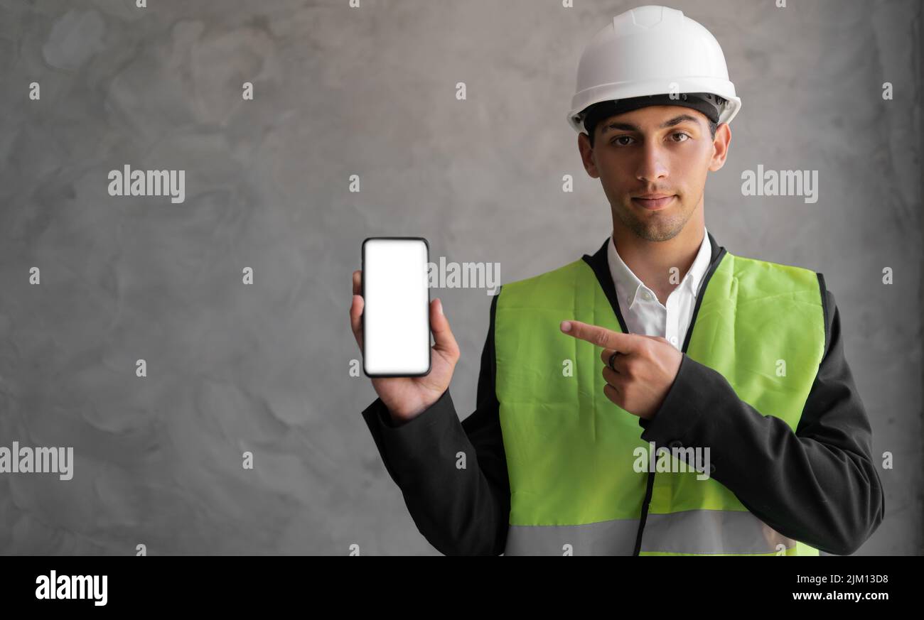 smiling Arabic male engineer or builder in white helmet and overall ...