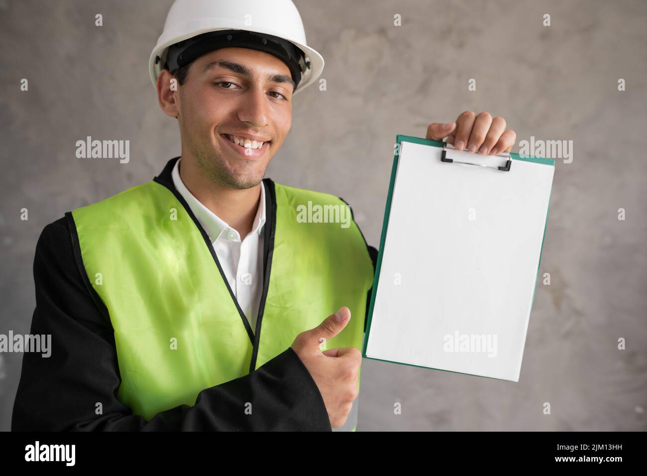 Engineer in a hard hat with a blank clip board in his hands, a place ...