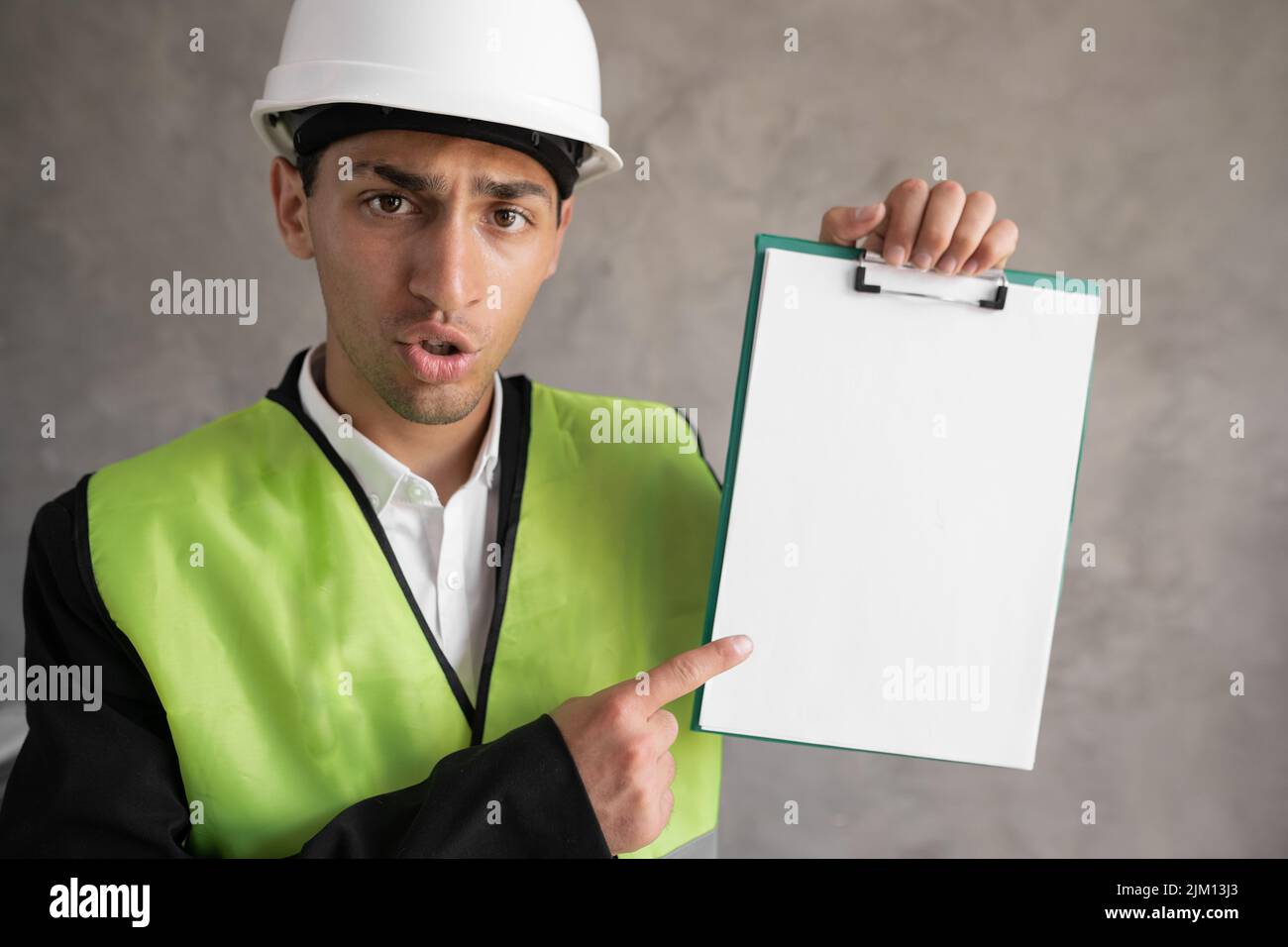 Muslim builder showing finger on blank clip board, empty space, space ...