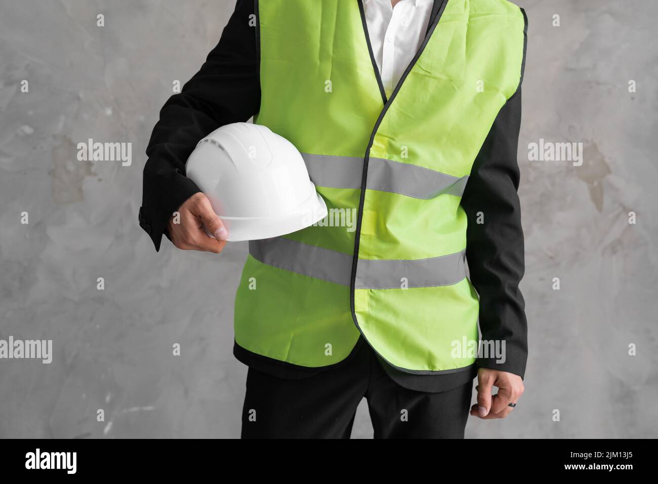 Close-up workwear and helmet in engineer or constructor hand as safety ...