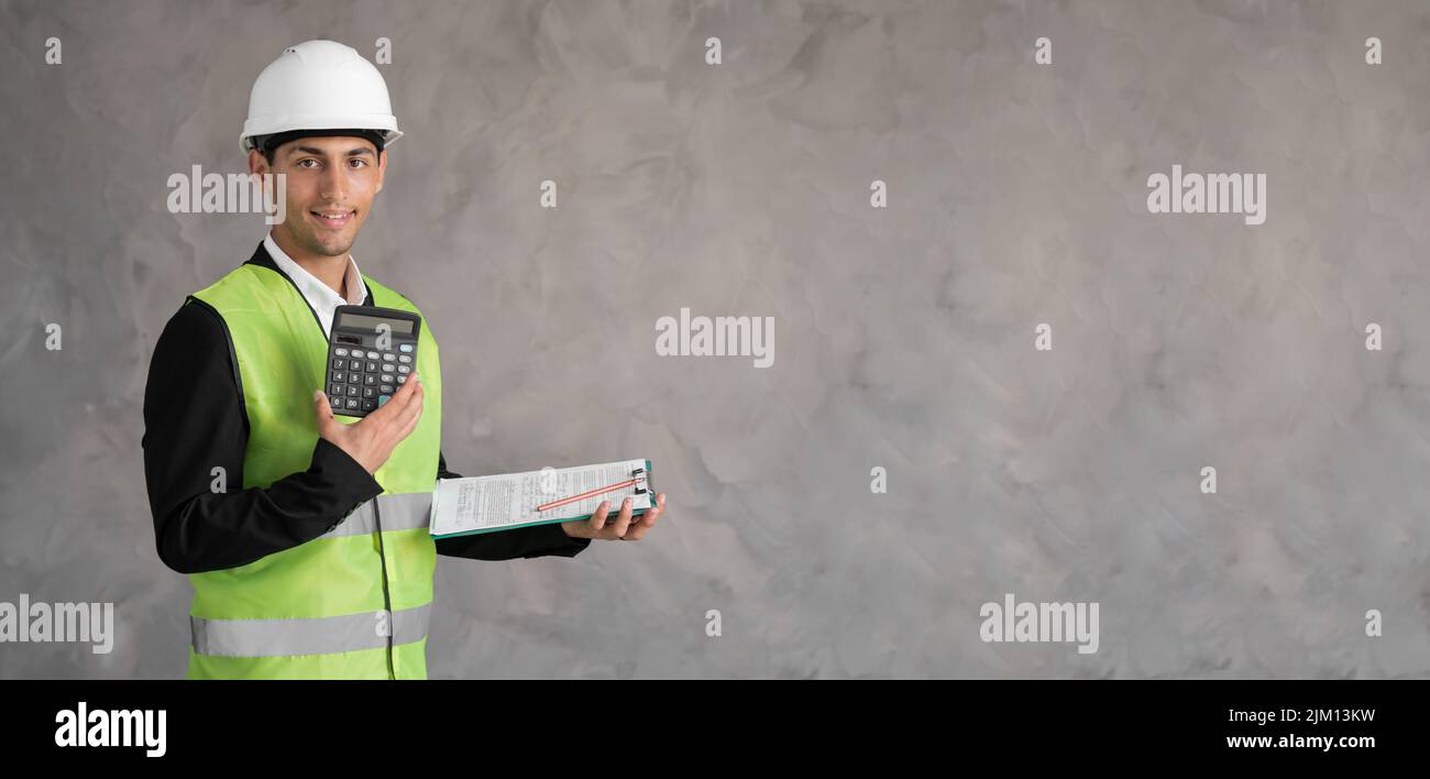 architect working on blueprint. Muslim engineer wearning in helmet on ...