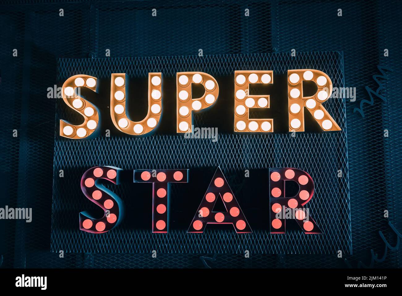 Glowing Super Star text with bulb illumination on dark metal background ...