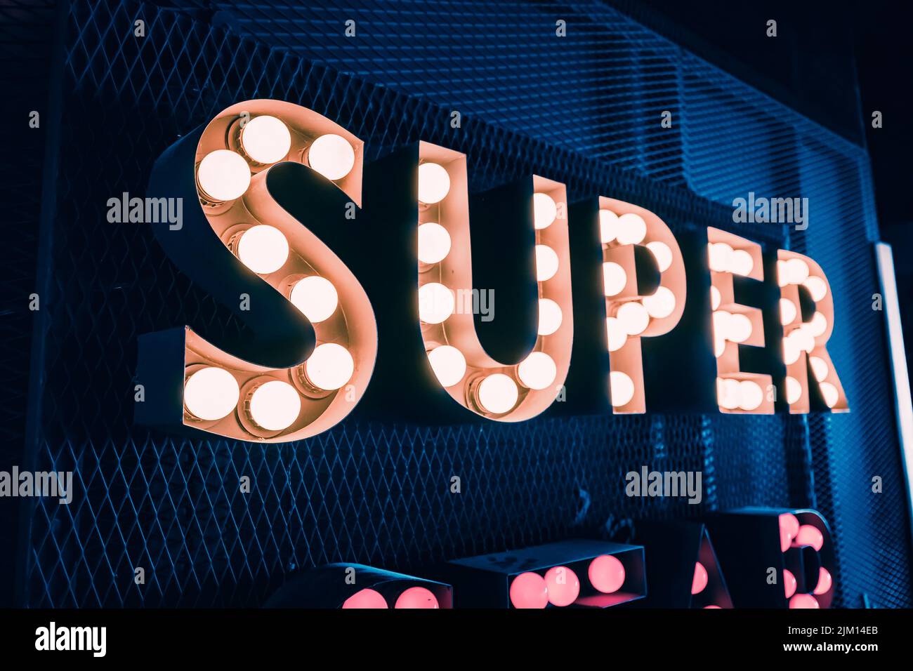 Glowing Super word with bulb illumination on dark metal background ...