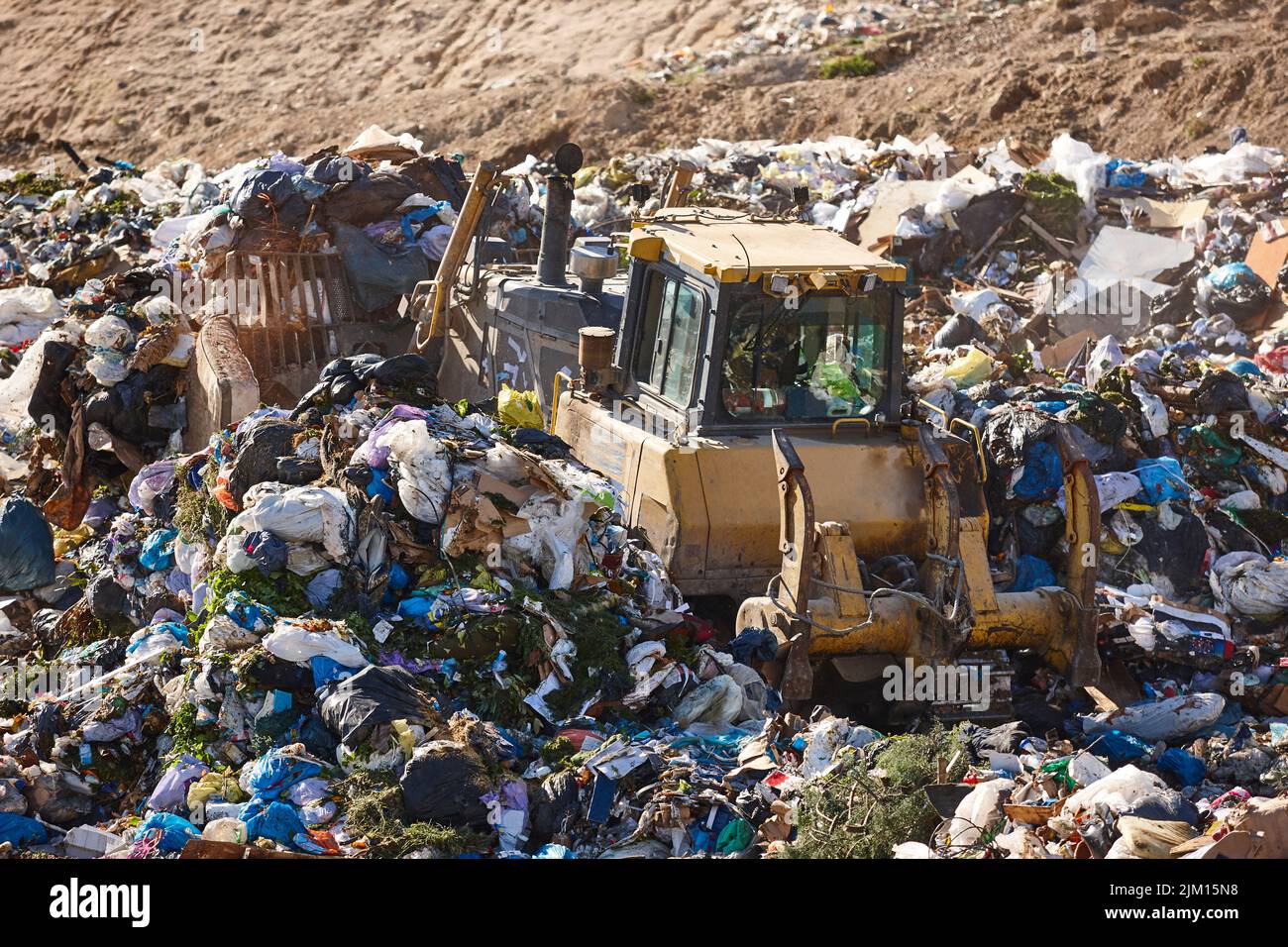 Heavy machinery shredding garbage in an open air landfill. Waste Stock ...