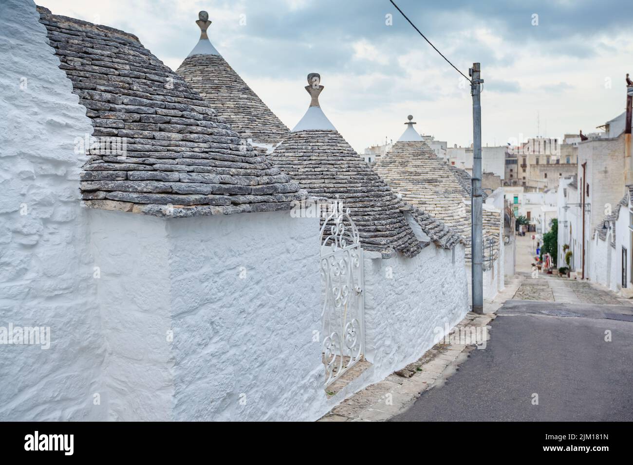 Beautiful town of Alberobello with Trulli houses among green plants and ...