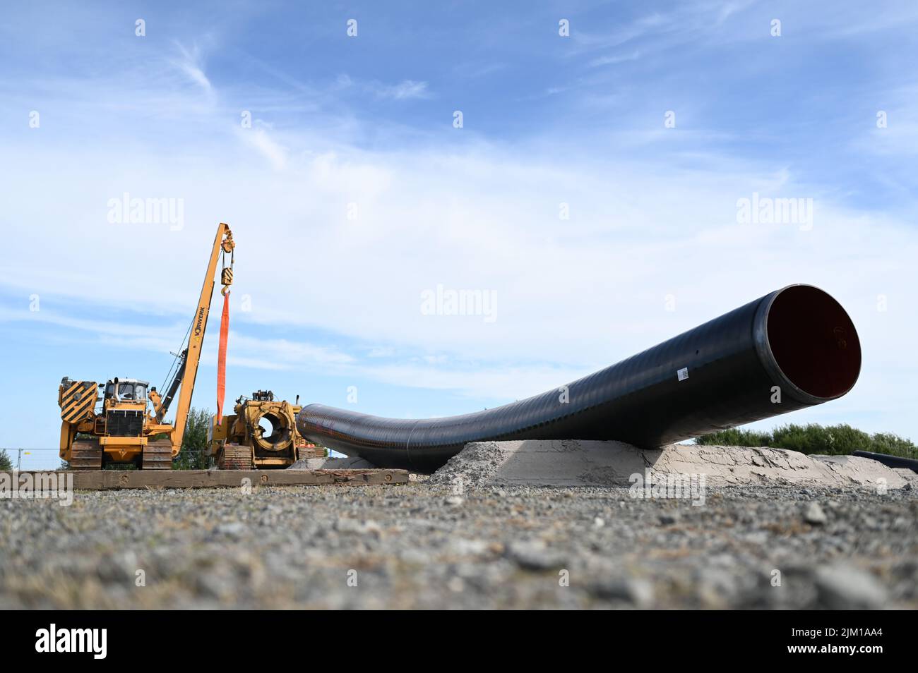 Friedeburg, Germany. 04th Aug, 2022. A construction machine lays pipes ...
