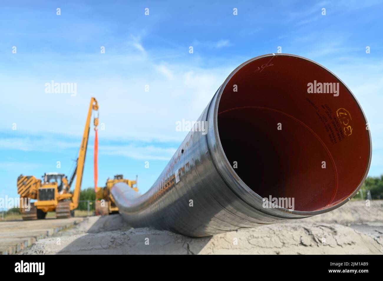 Friedeburg, Germany. 04th Aug, 2022. A construction machine lays pipes ...
