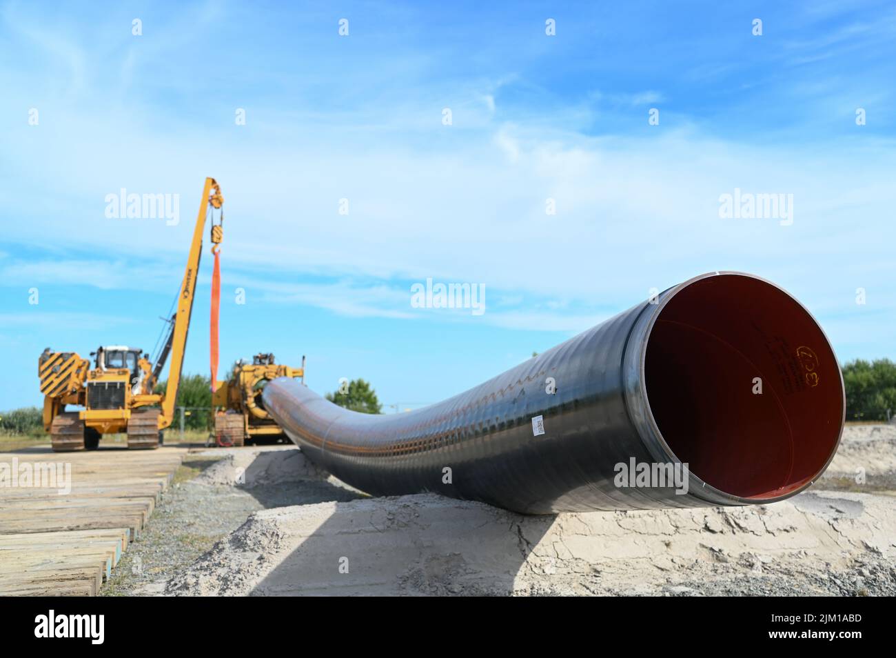 Friedeburg, Germany. 04th Aug, 2022. A construction machine lays pipes ...