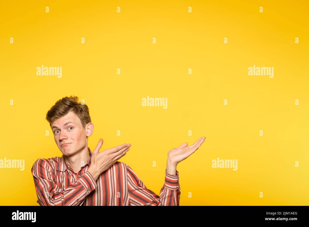 smiling young man pointing sideways hands showing Stock Photo - Alamy