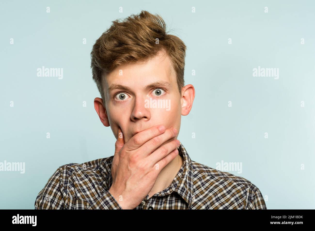 puzzled confused shocked amazed man cover mouth Stock Photo - Alamy