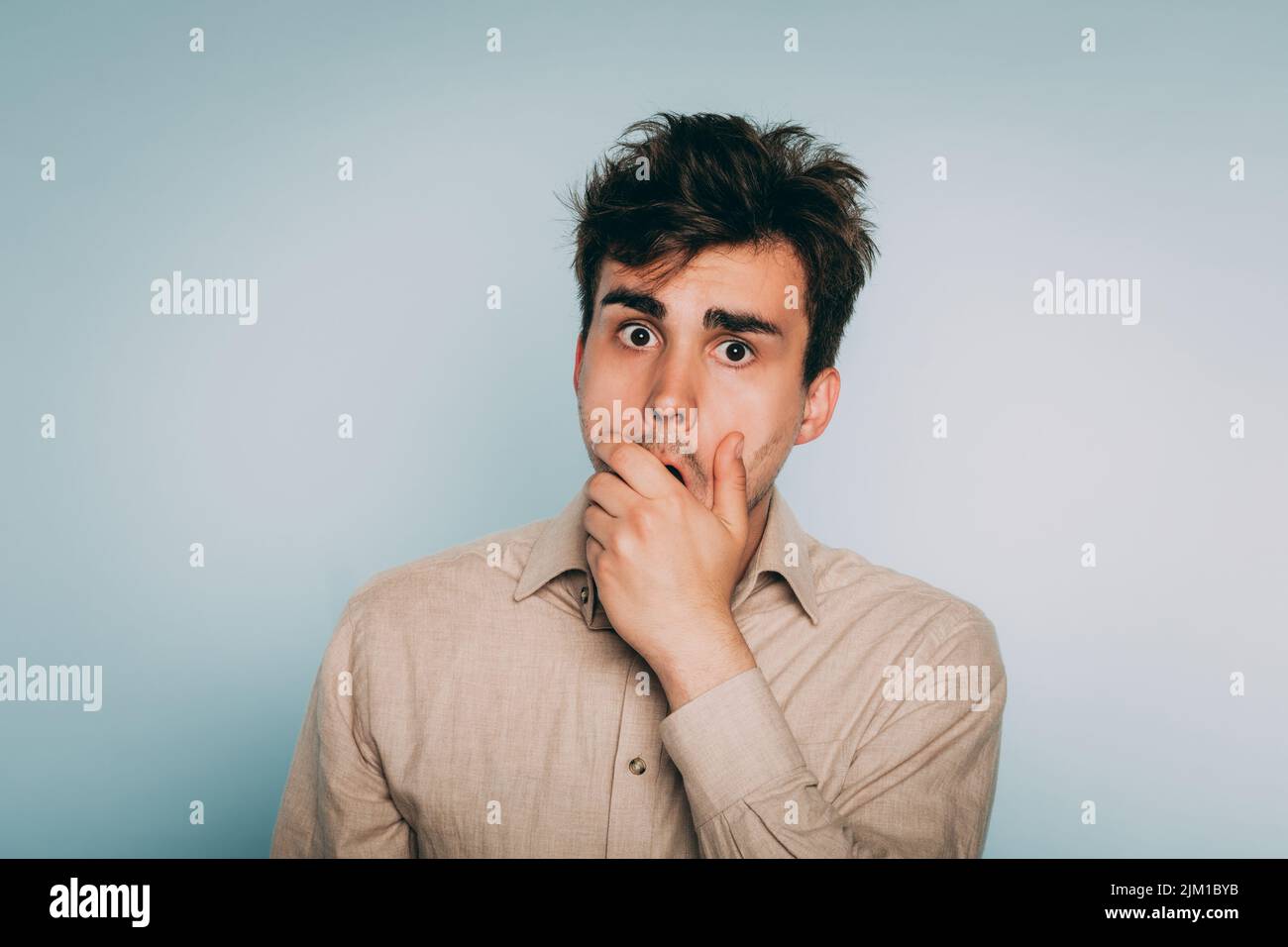 terrified shocked dismayed man cover mouth emotion Stock Photo - Alamy