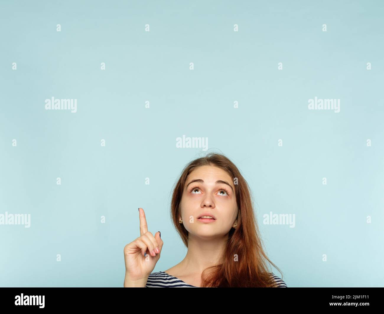 look up advertising above girl point up finger Stock Photo - Alamy