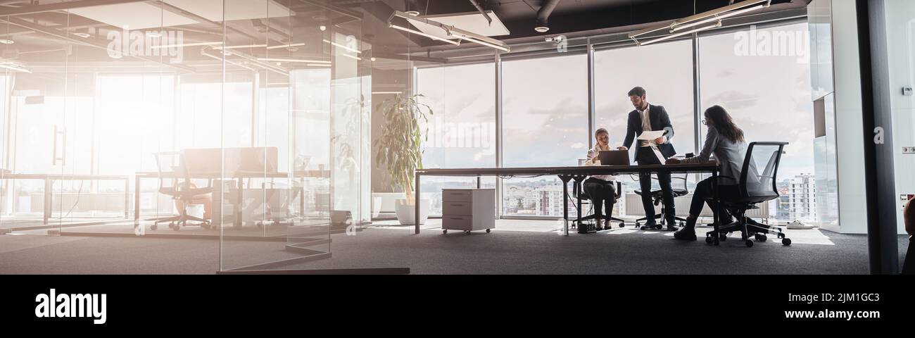 Team of businessmen communicating together in modern office with ...