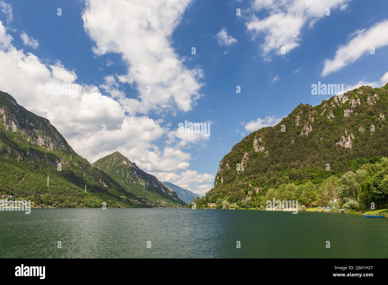 Green waters of the lake (Lago d'Idro) framed by alpine rocks with ...