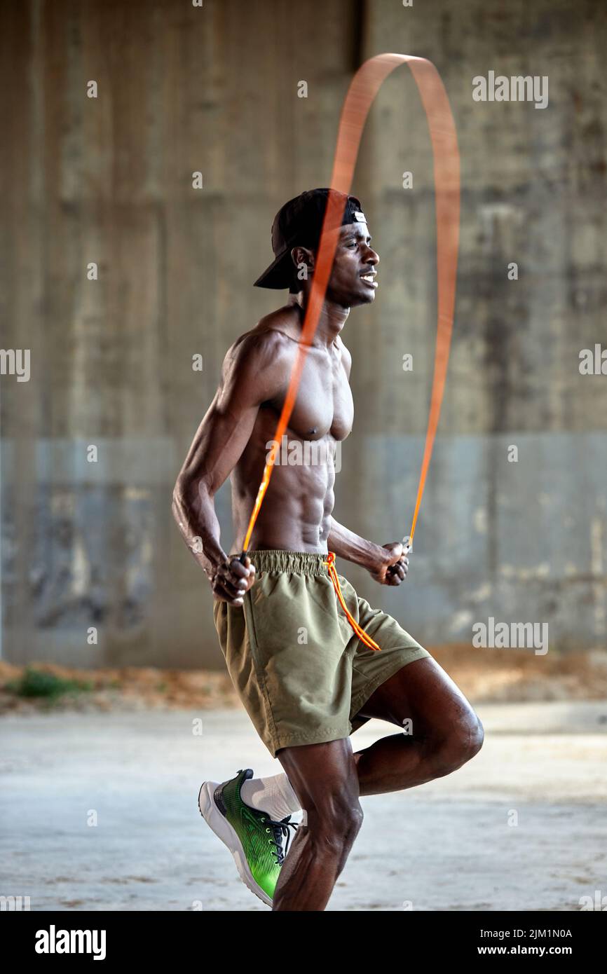 Muscular black man skipping rope. Portrait of muscular young man ...