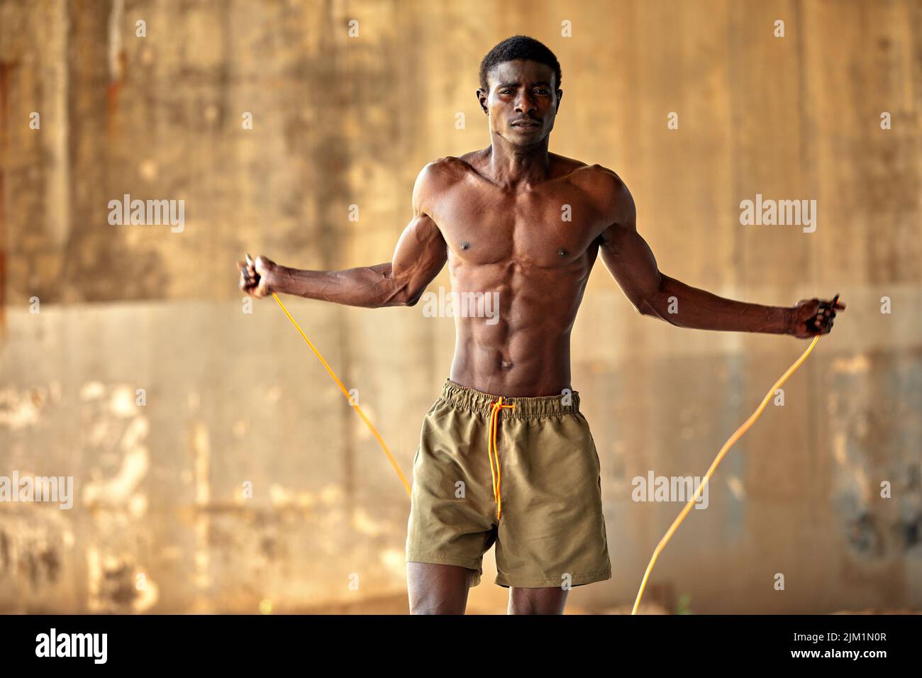 Muscular black man skipping rope. Portrait of muscular young man ...
