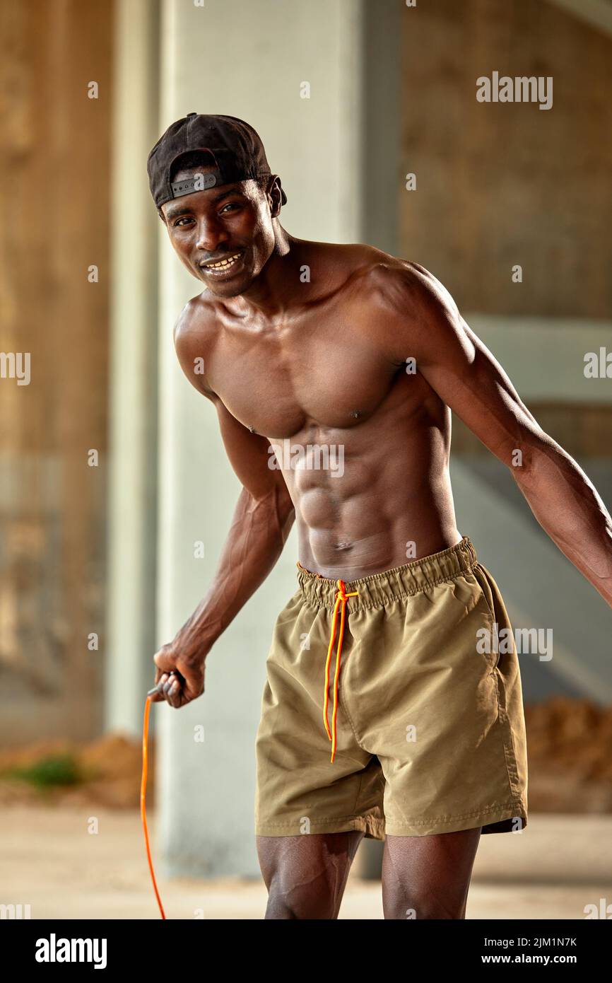 Muscular black man skipping rope. Portrait of muscular young man ...