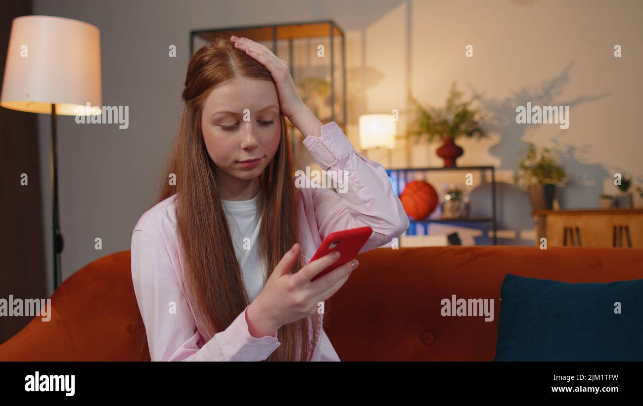Young redhead teenager child girl use smartphone typing browsing, loses ...