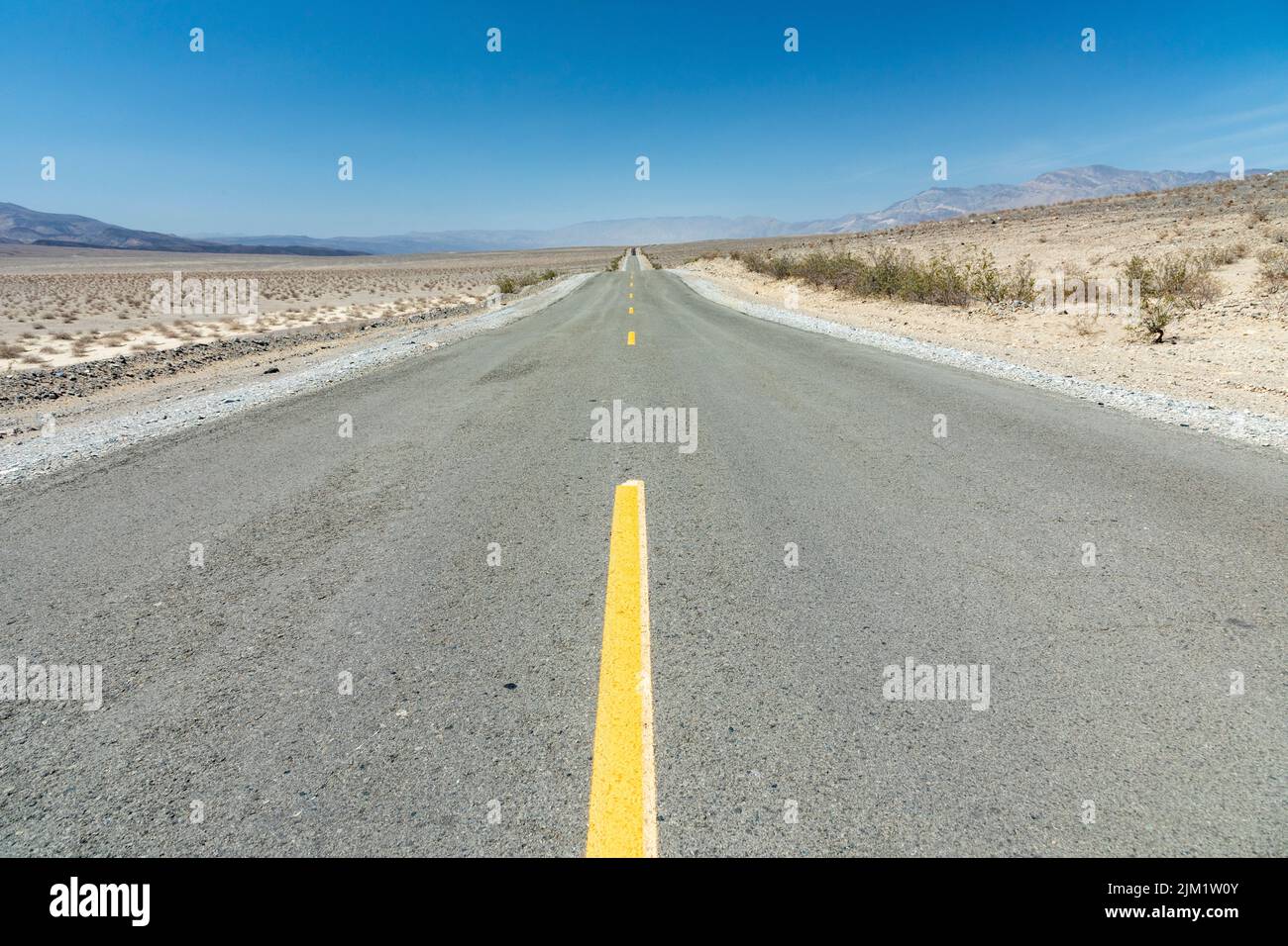 empty straight road thru the death valley with yellow median, USA Stock ...