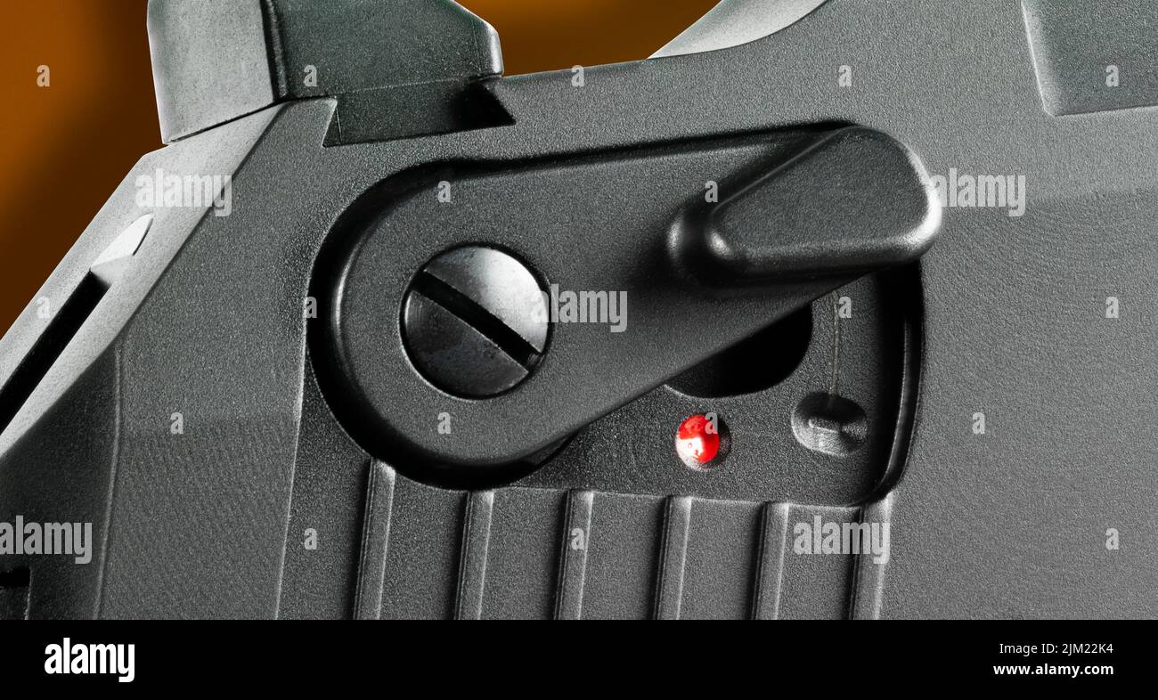 Safety off on a semi auto pistol on a brown background with drop shadow ...