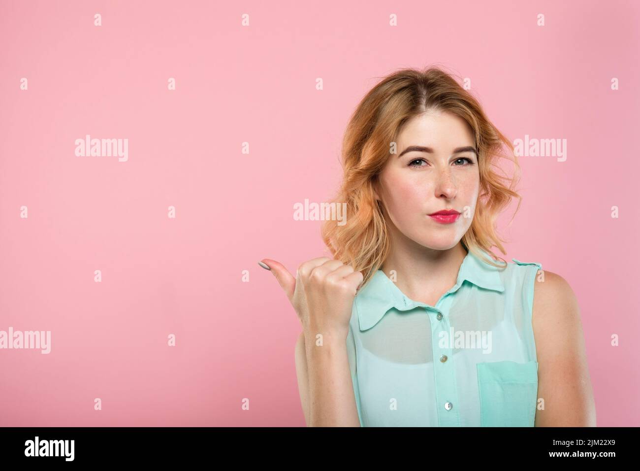 look there girl point thumb empty space advertise Stock Photo - Alamy
