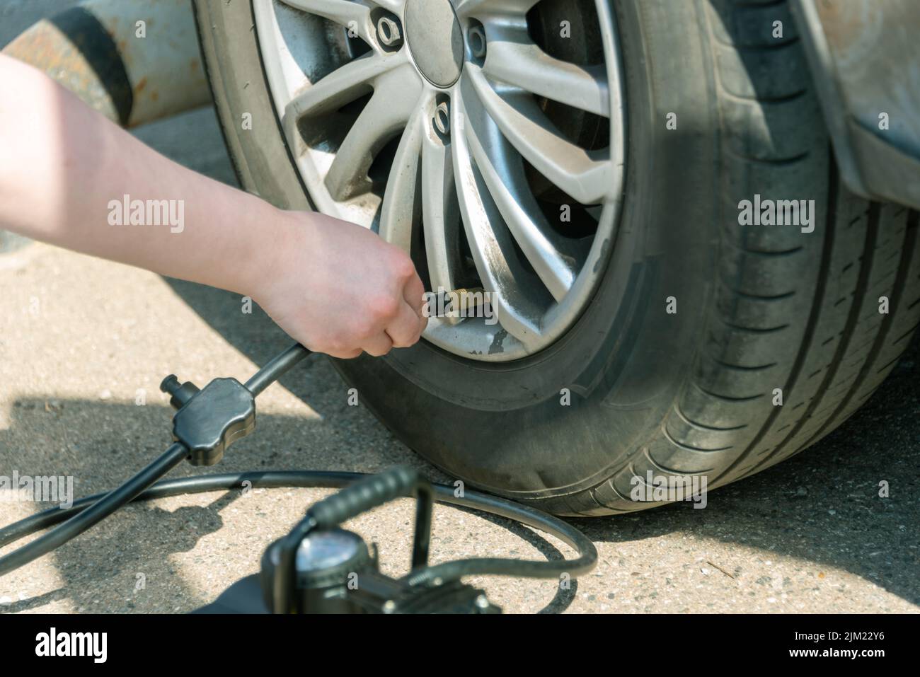 Connecting the compressor to the car tire, checking the air pressure ...