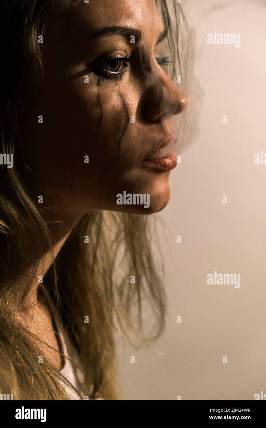 Crying young woman releasing cigarette smoke from mouth. Portrait of a ...