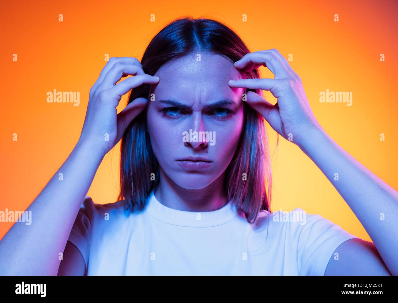 Closeup face of young annoyed girl looking at camera isolated on orange ...