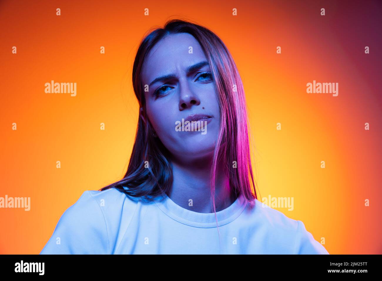 Closeup face of young annoyed girl looking at camera isolated on orange ...
