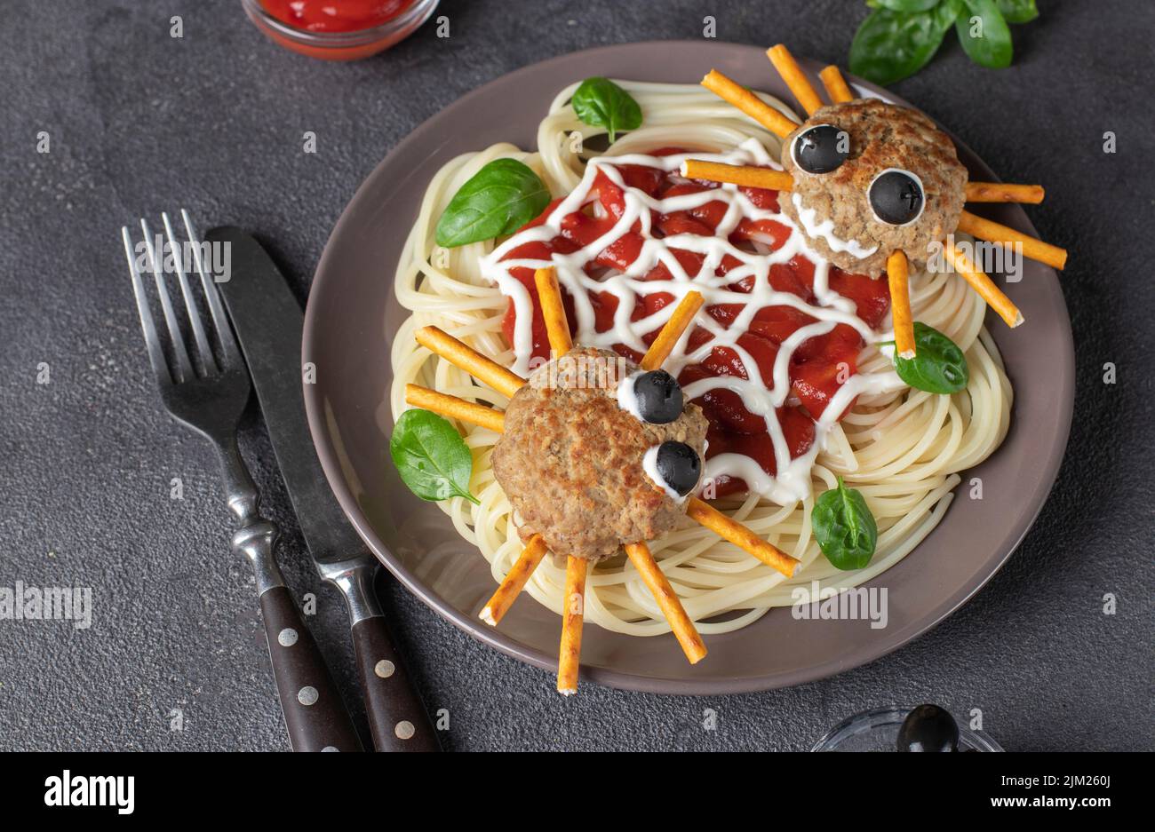 Cutlets look like spiders with olives and straws, served with spaghetti ...