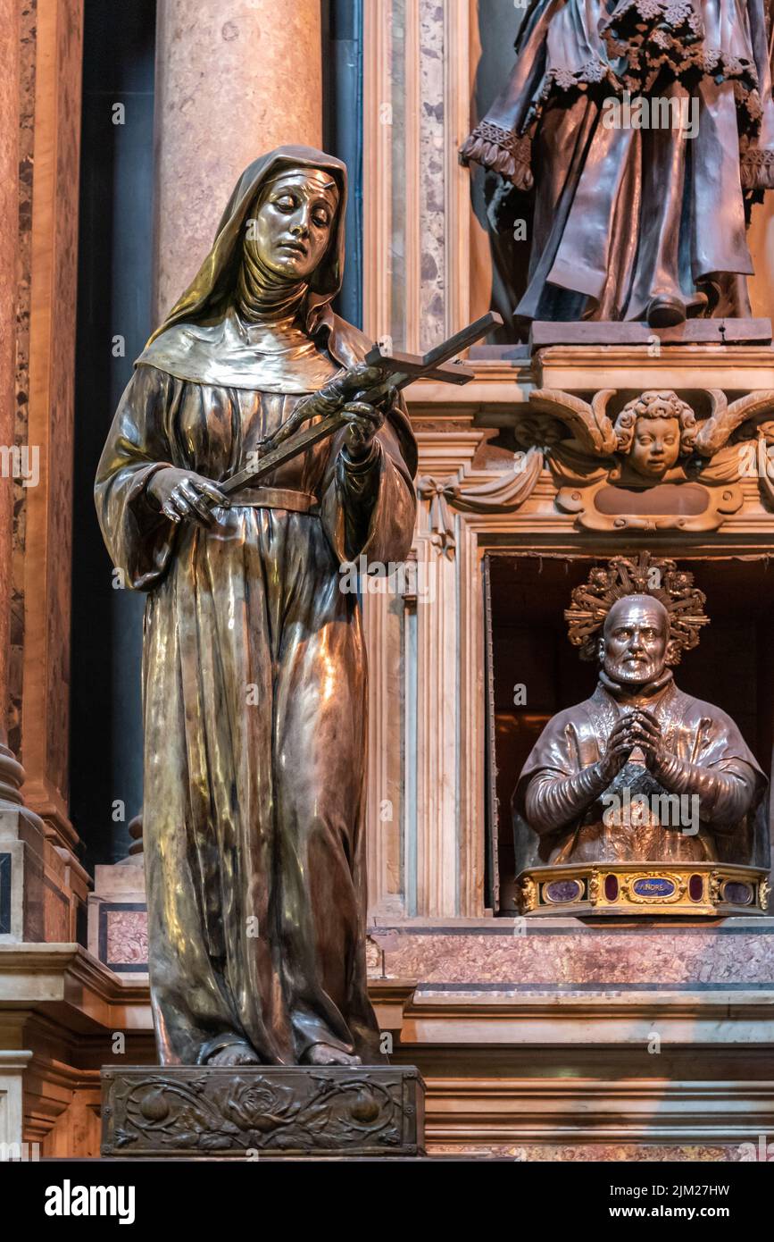 Close-up on metal statue of nun holding a crucifix inside catholic ...