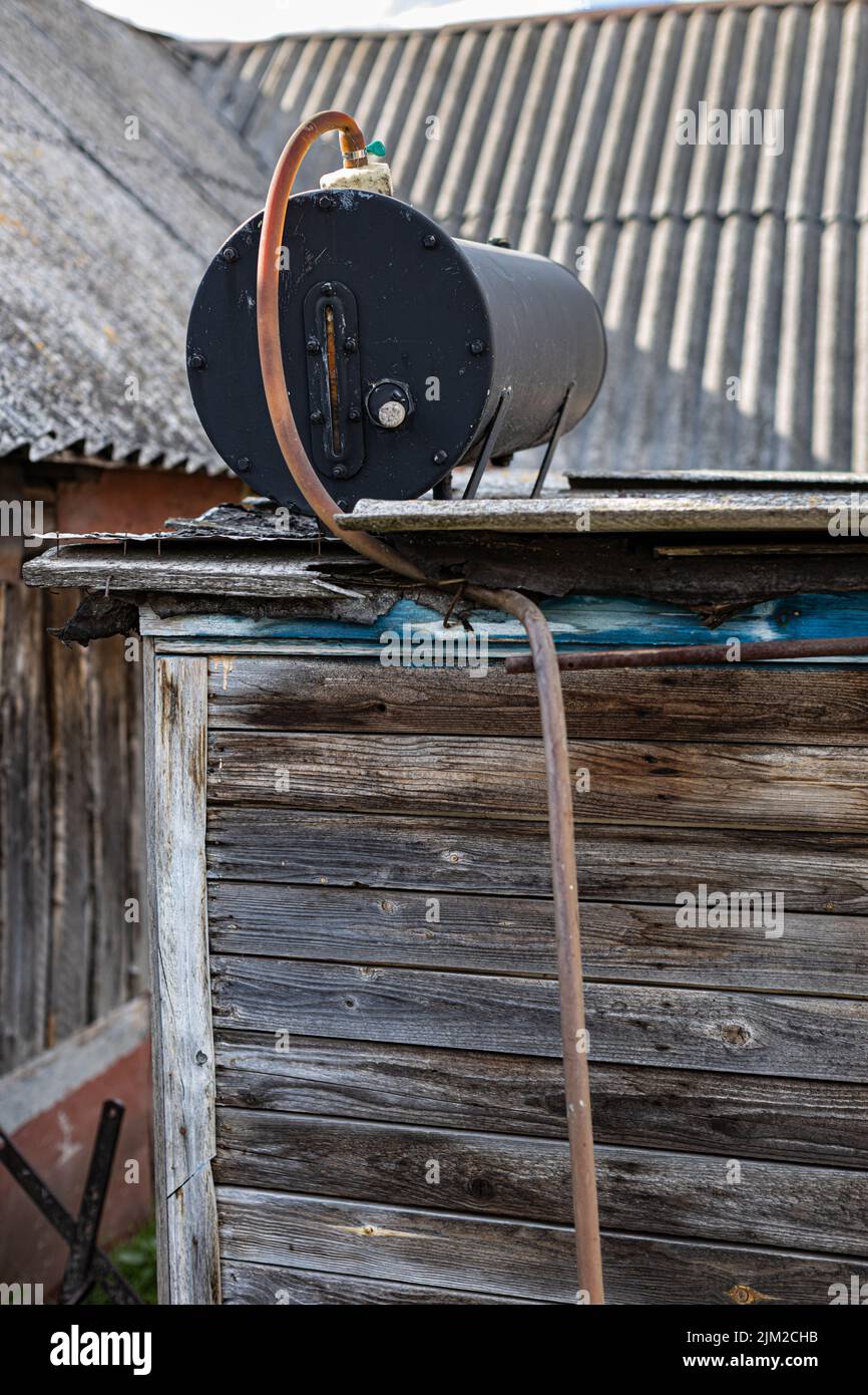an old heating tank stands on the roof of a summer shower in the ...