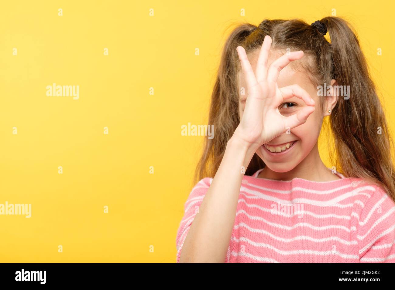 ok gesture smiling joyful girl look through finger Stock Photo - Alamy