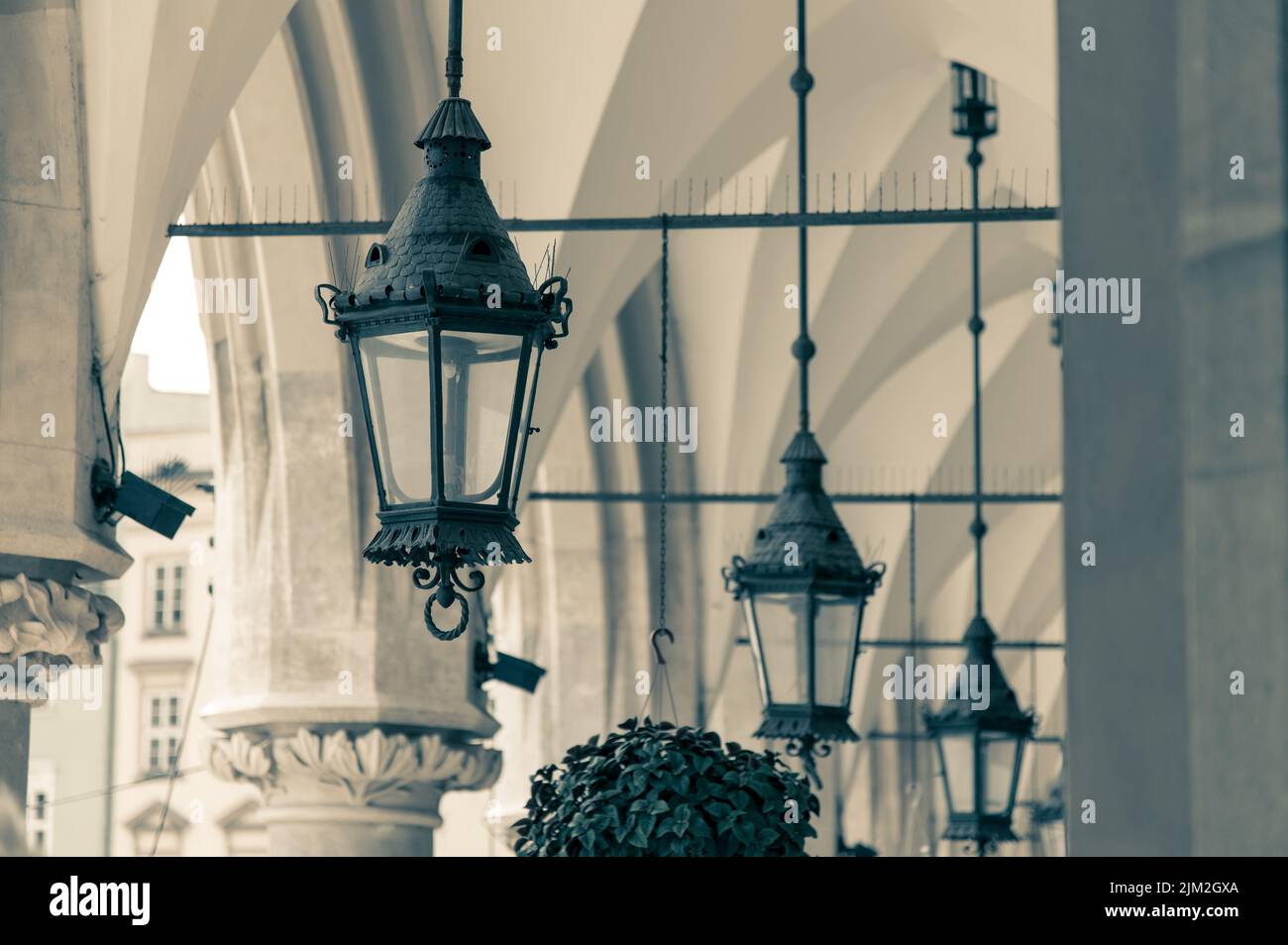 Monochromatic row of ancient lantherns in the gothic arcade Stock Photo ...