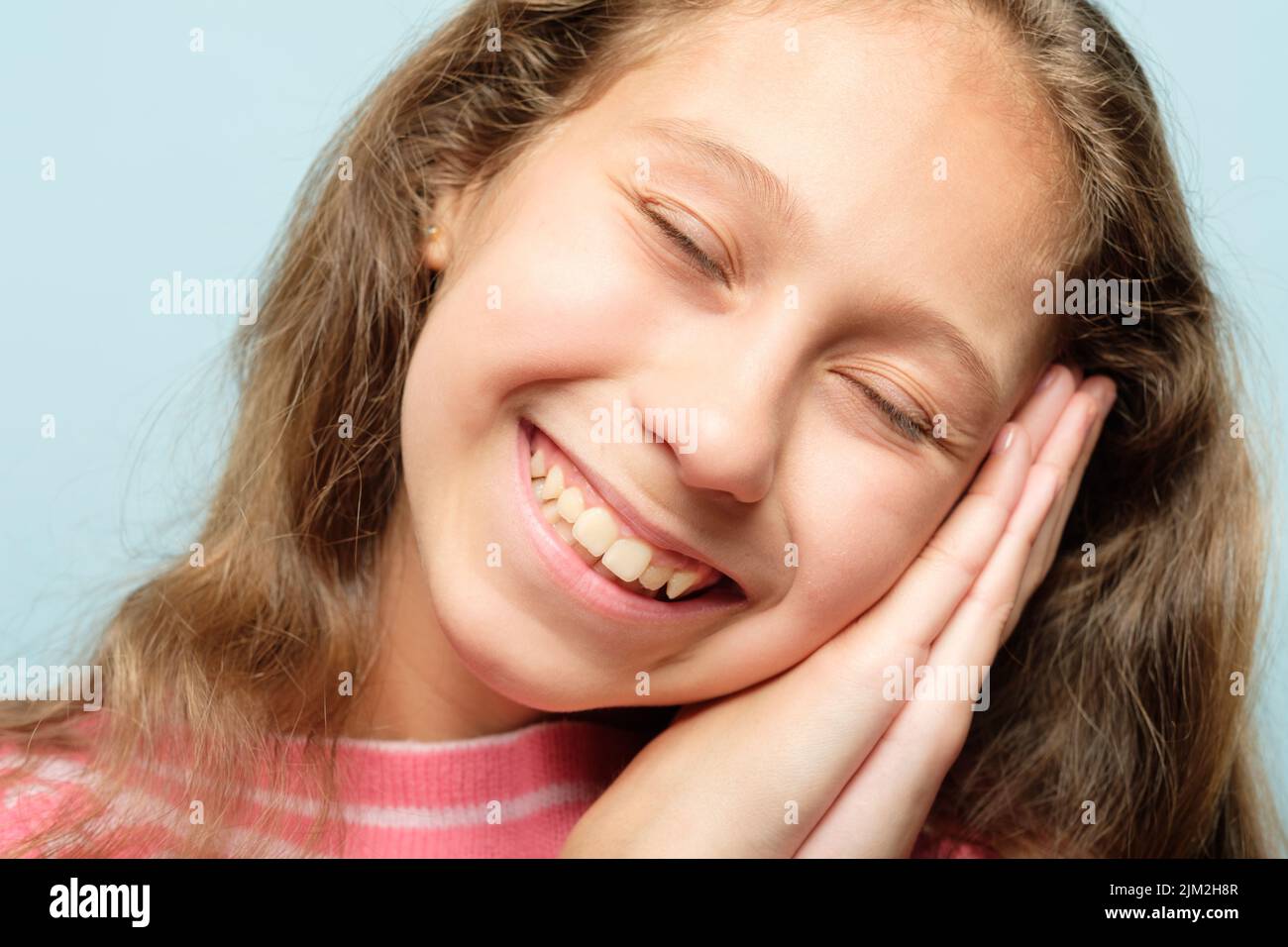 girl pretend sleep hands smiling facial expression Stock Photo - Alamy