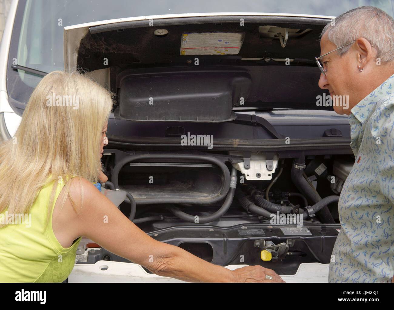 A couple fixes a car engine breakdown Stock Photo - Alamy
