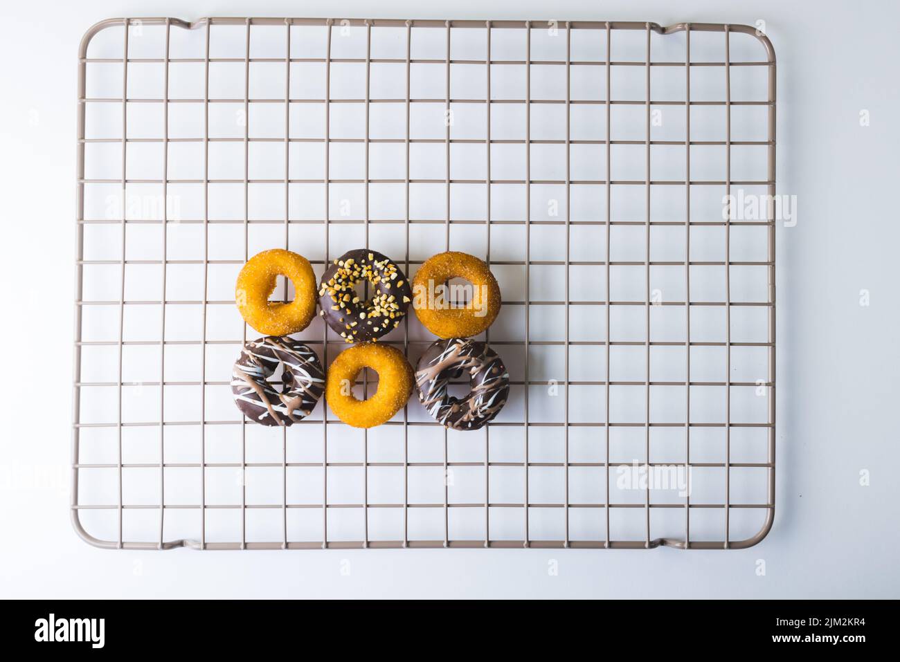 Directly above view of various fresh donuts arranged on cooling rack ...
