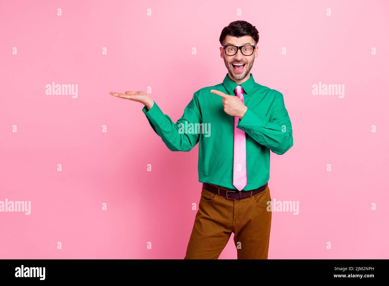 Portrait of young smiling guy wear green shirt hold hand promote new ...