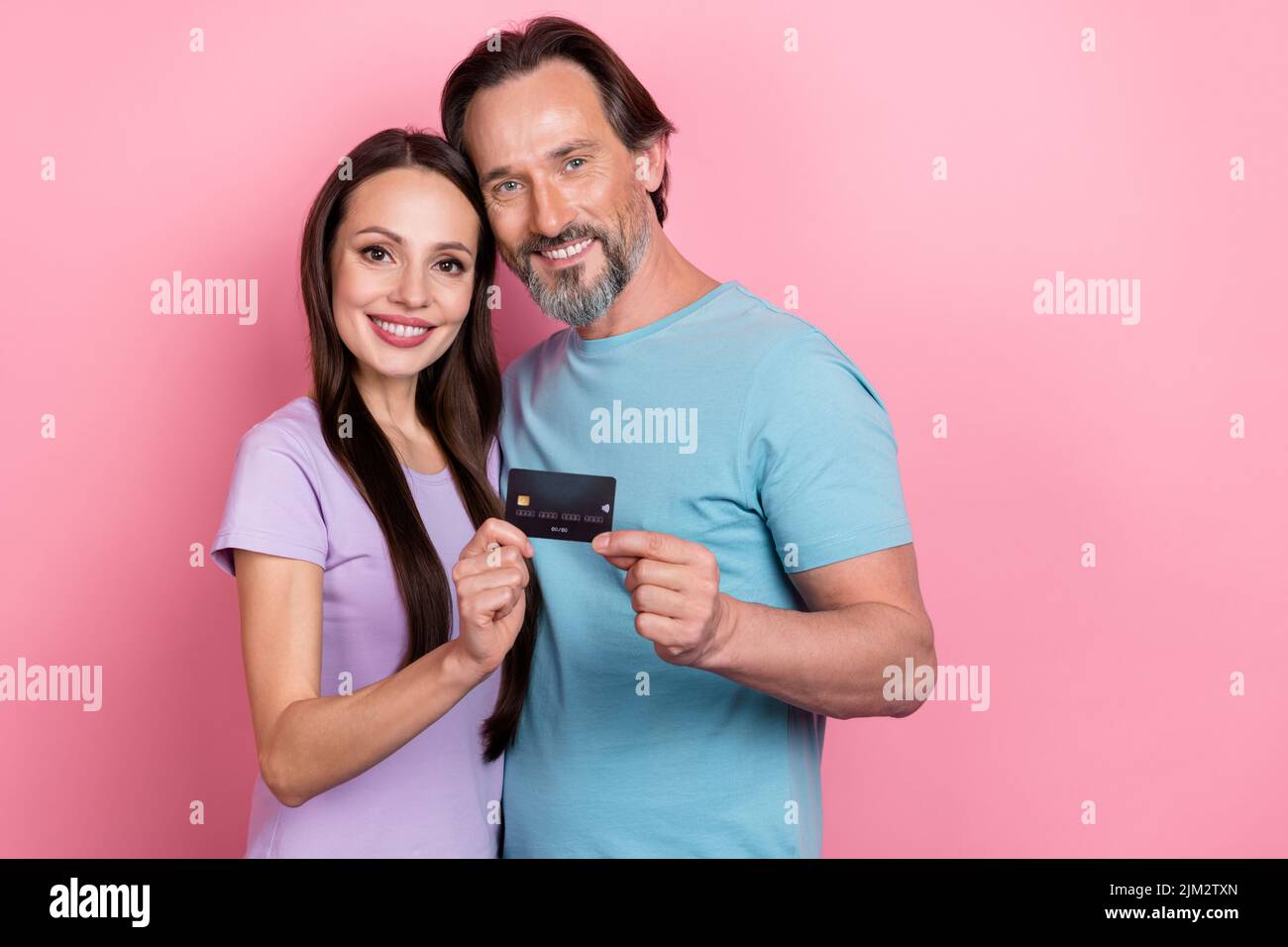 Portrait of two cheerful positive people hold demonstrate plastic debit ...