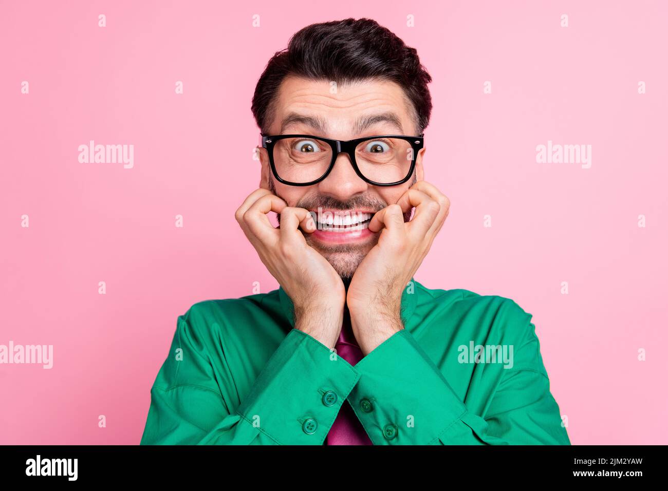 Closeup photo of young nervous guy bite fingers lips smiling can not ...